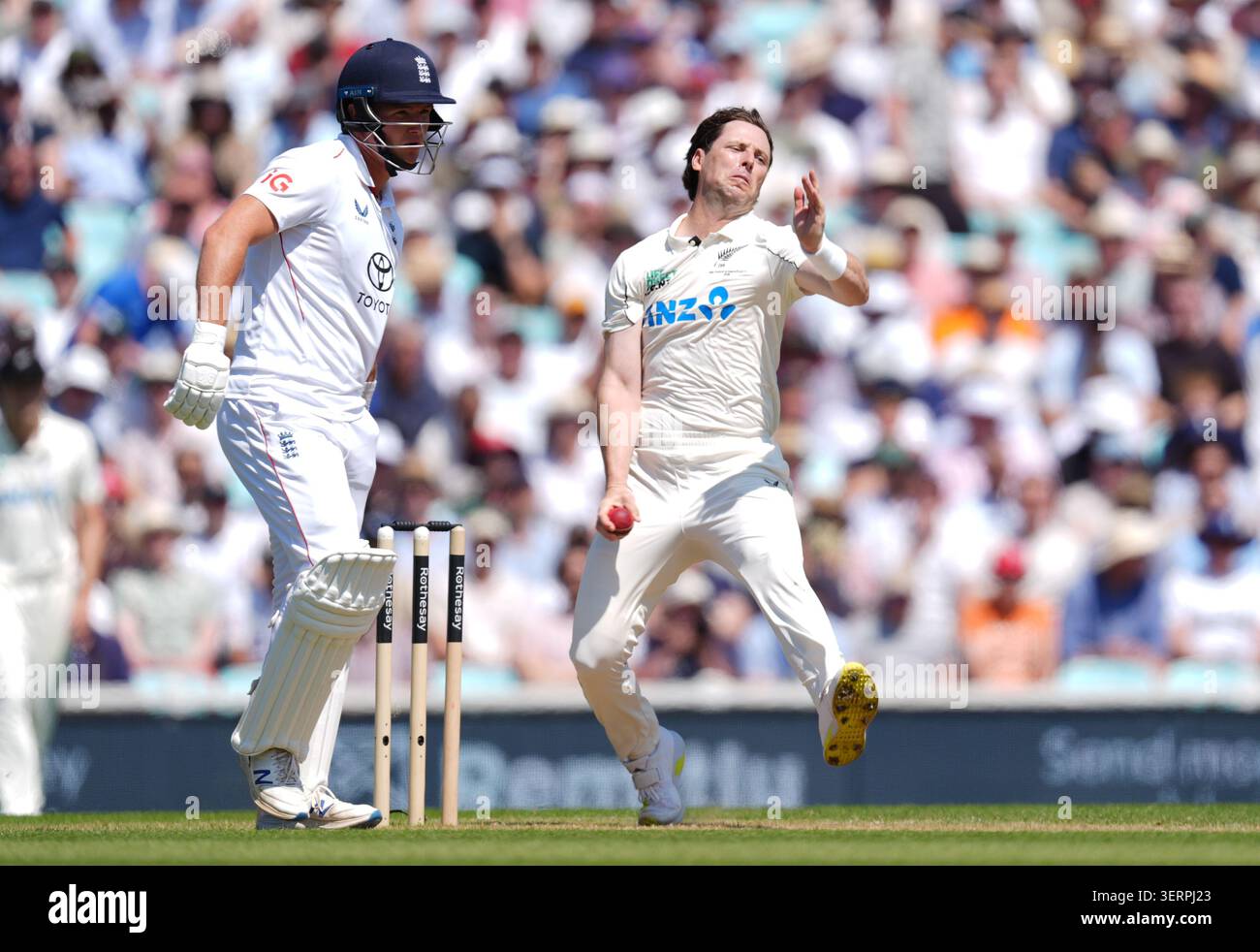 New Zealand's Matt Henry bowling as England's Sonny Baker looks on ...