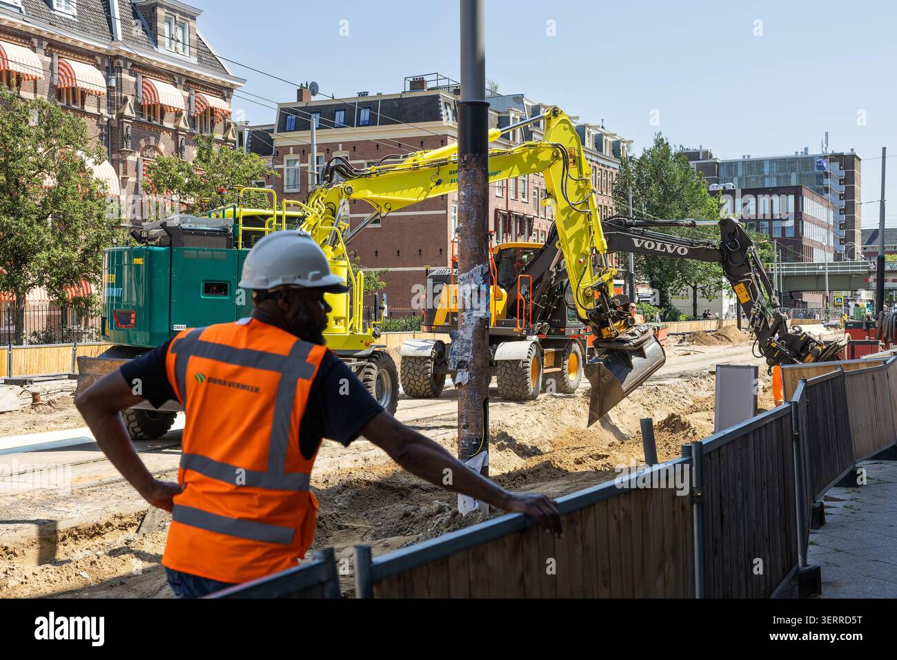 AMSTERDAM - Construction workers at work in the sun. Due to the warm ...