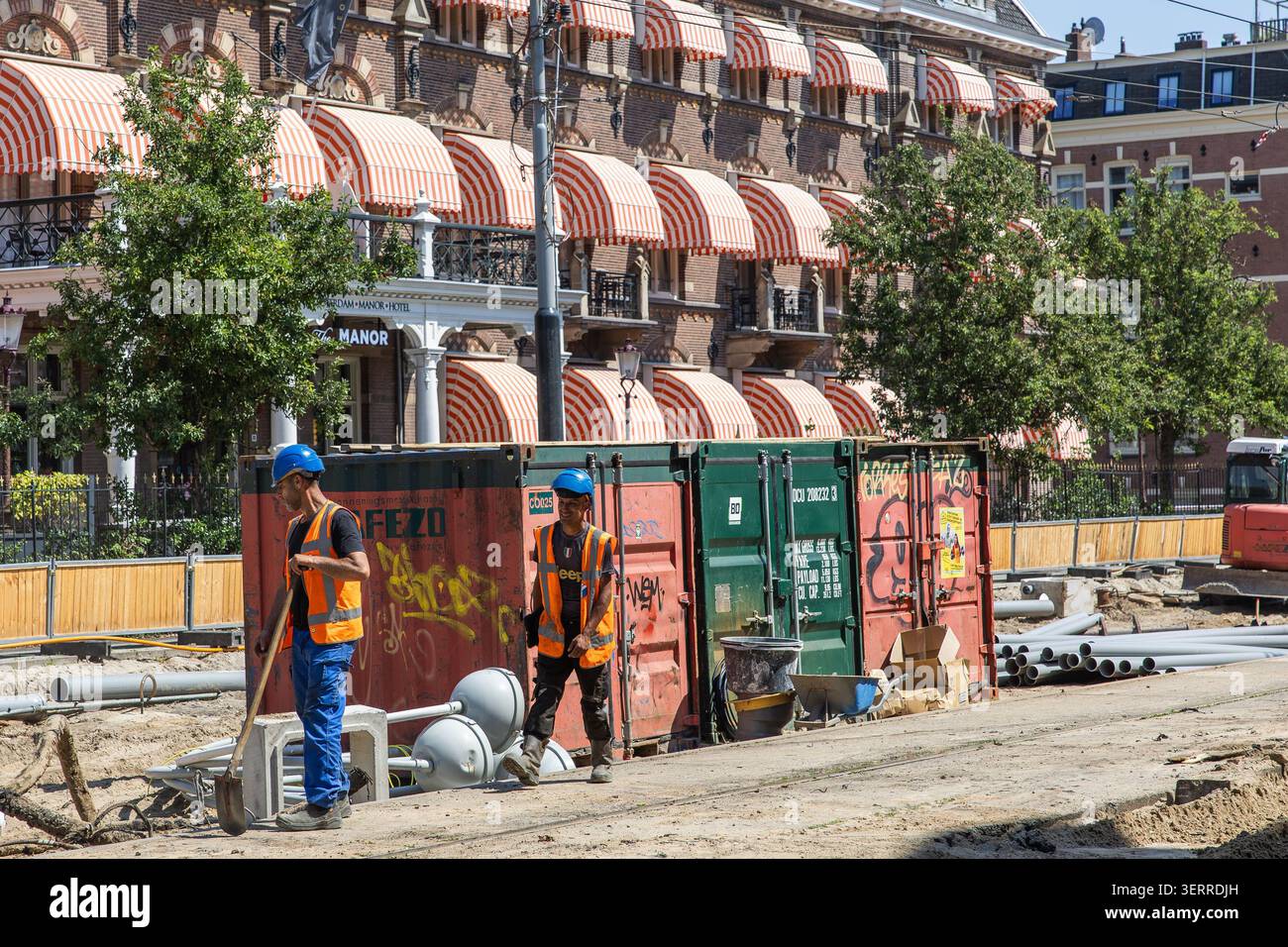 AMSTERDAM - Construction workers at work in the sun. Due to the warm ...
