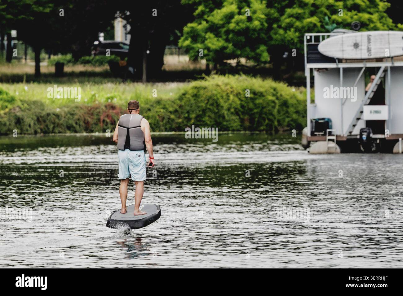 A man on an electric surfboard, taken in the district of Koepenick in ...