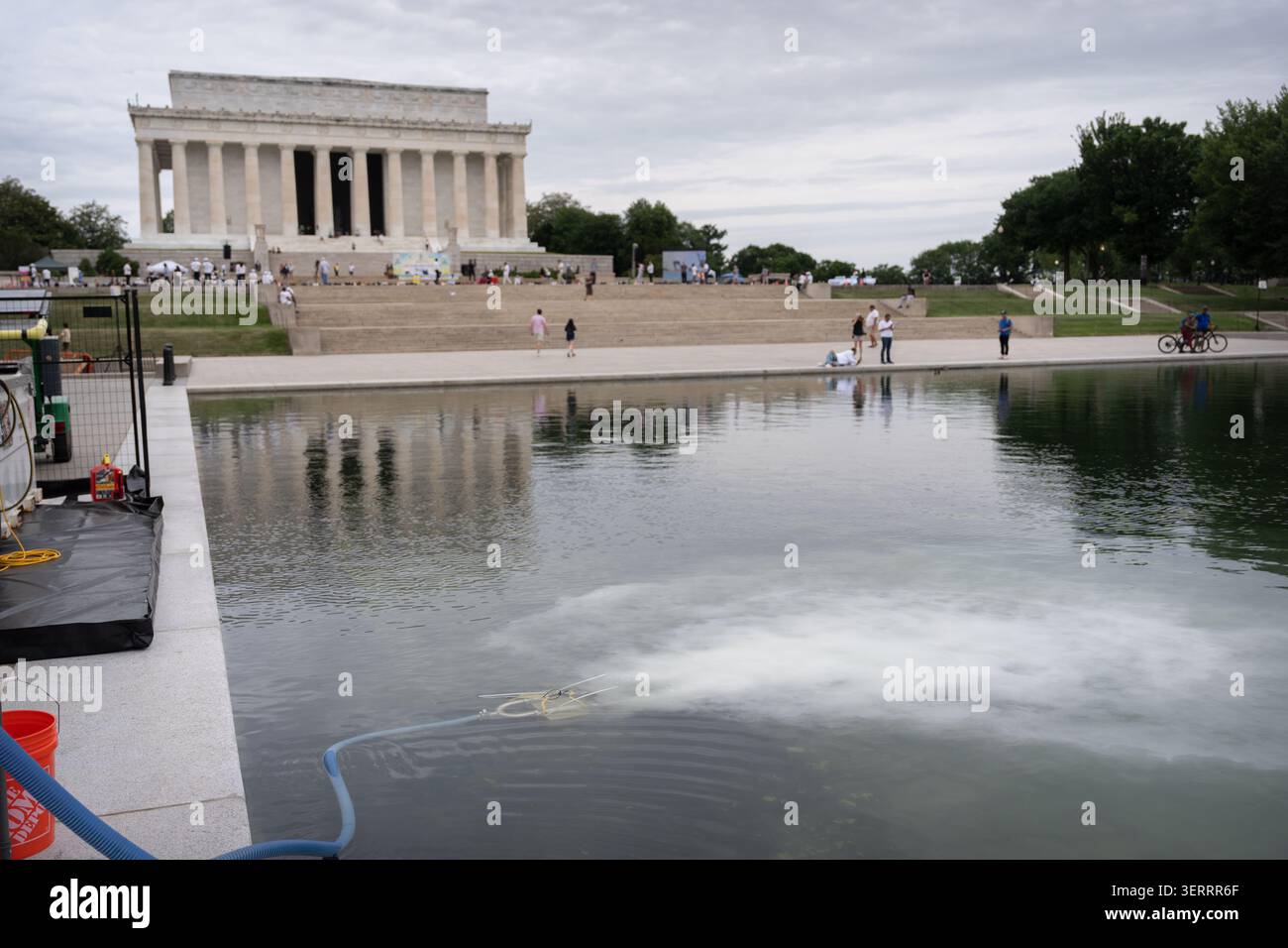 Bubbles emanate from a hose in the Lincoln Memorial Reflecting Pool ...