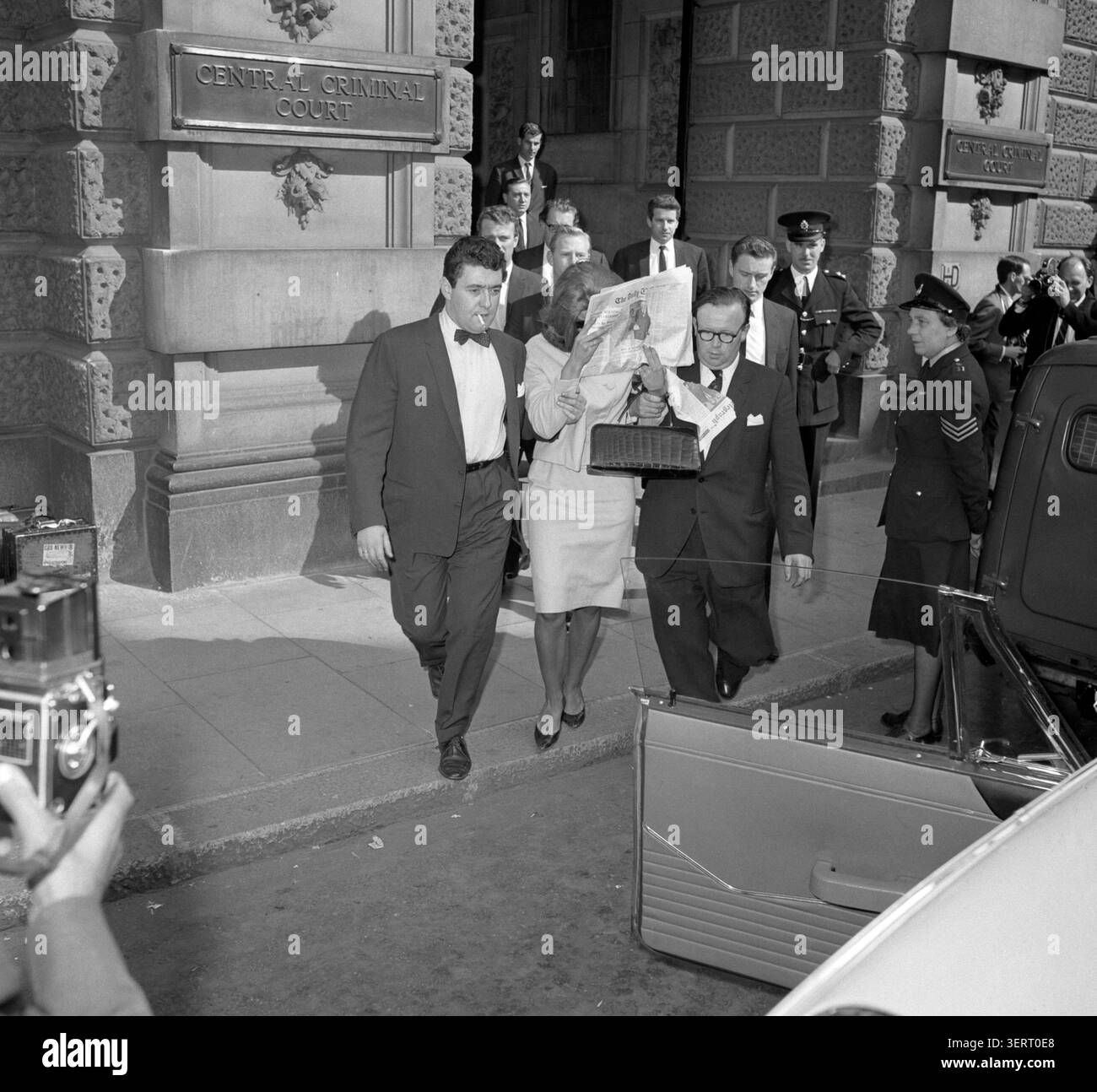 Shielding her face with a newspaper Sylvia Parker leaves London's Old ...
