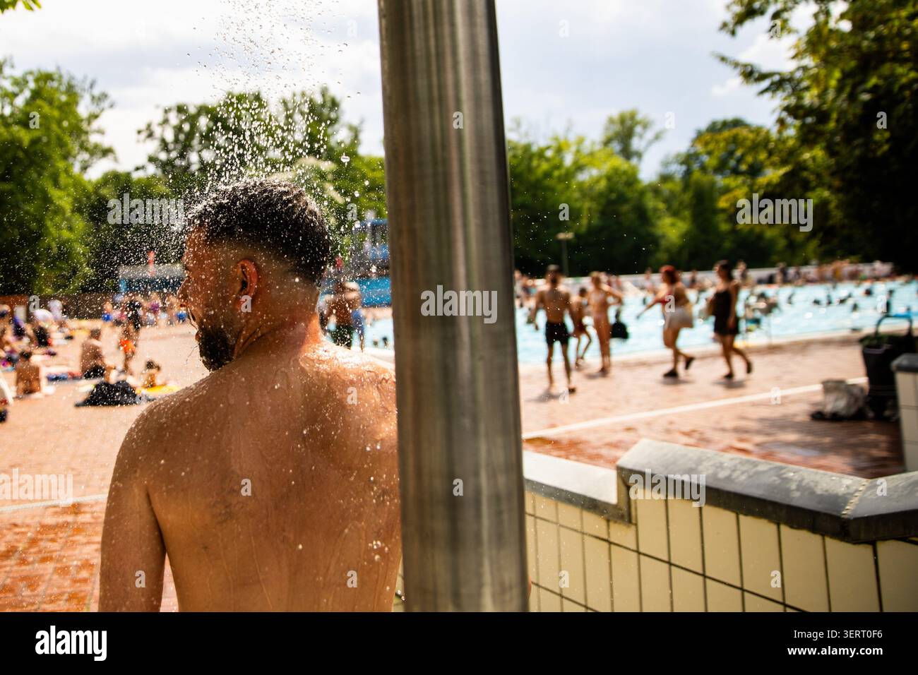 19 June 2026, Berlin: A swimmer stands under the water shower at the ...
