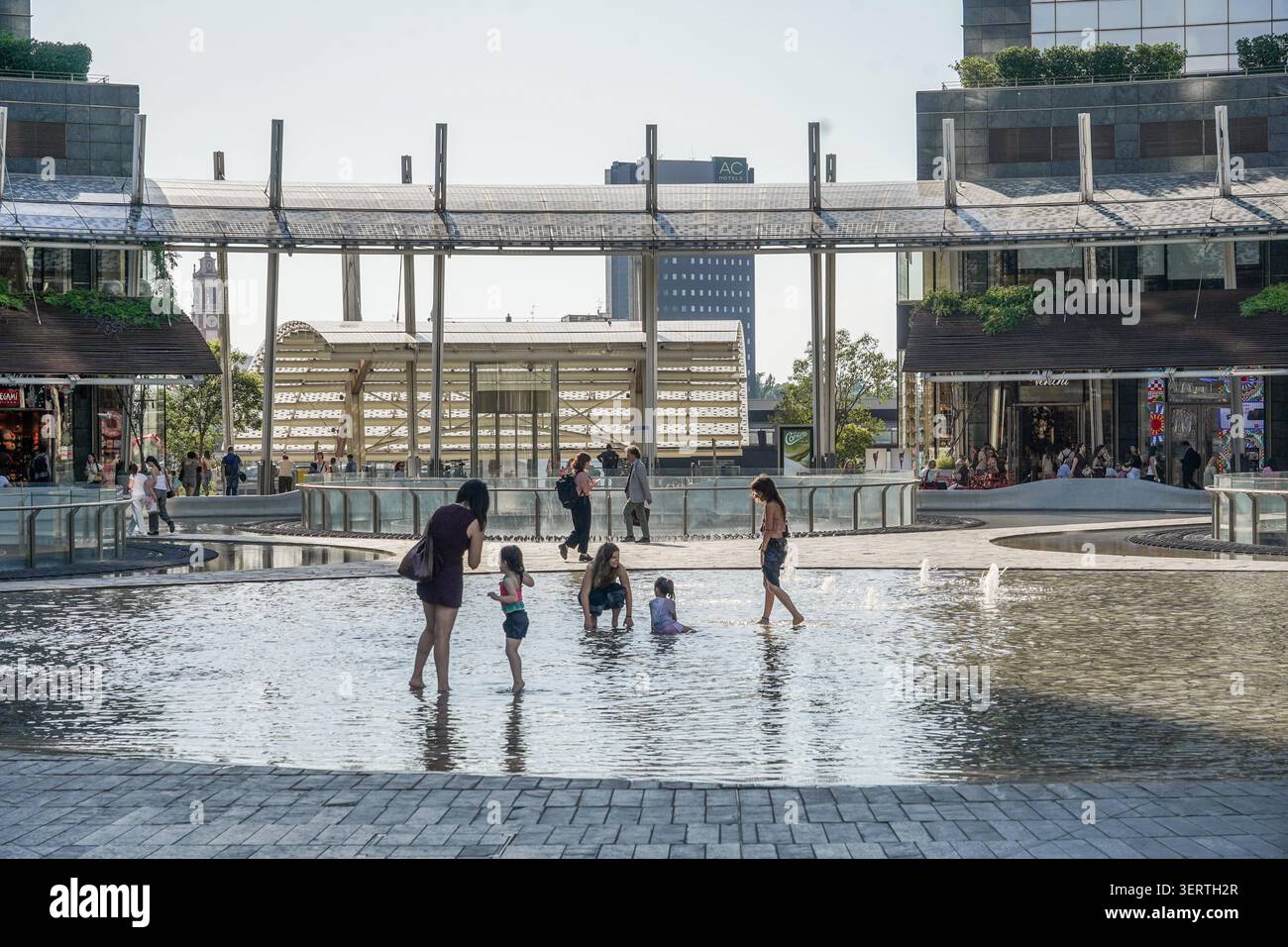 IPA85859519 - MILAN, June 19, 2026 - People cool off in the fountain in ...
