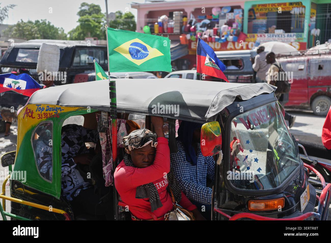 A tricycle taxi decorated with Haitian and Brazilian flags in support ...