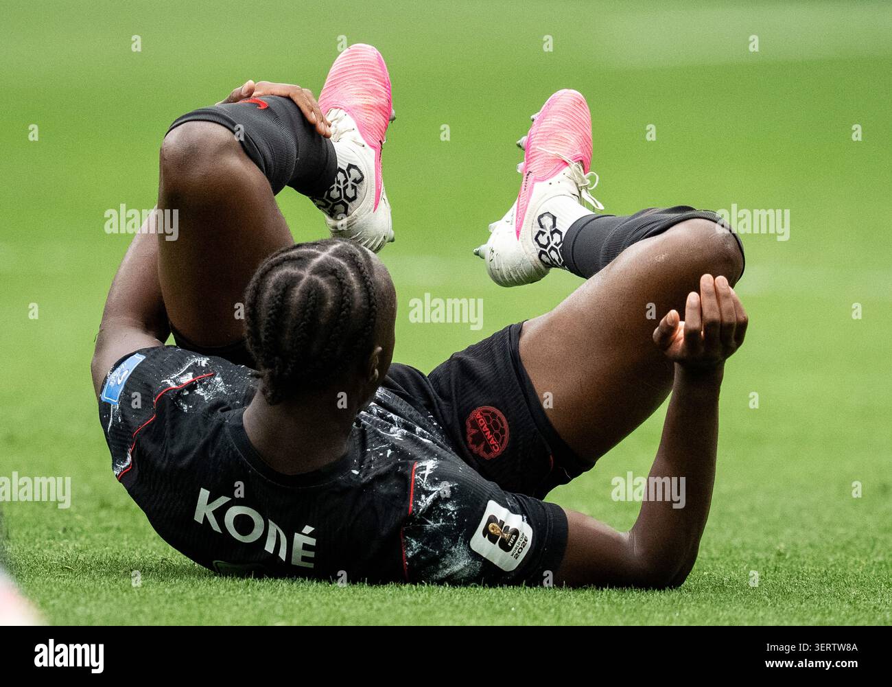 Canada's Ismael Kone rolls on the pitch after suffering a lower body ...