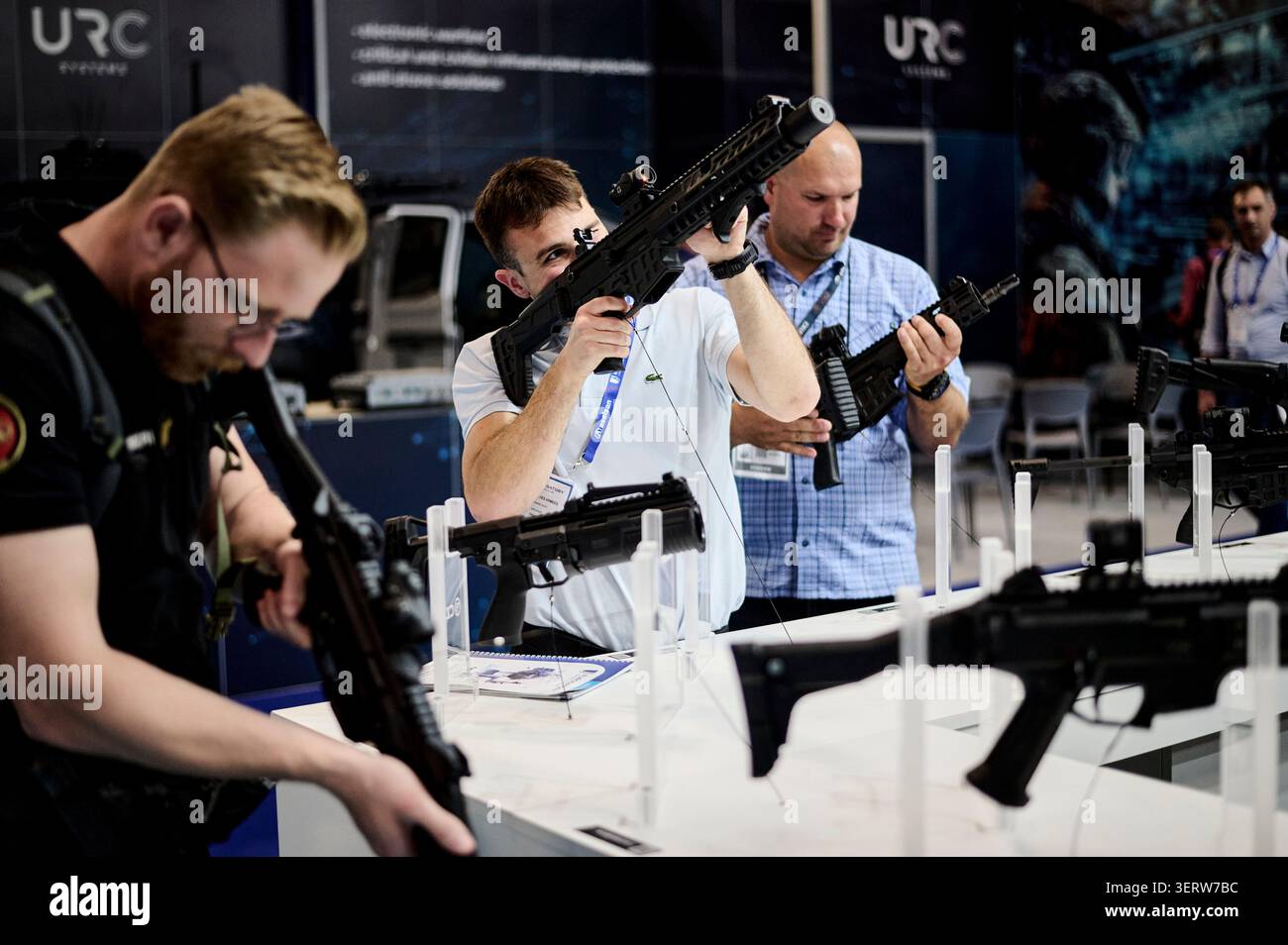 Visitors examining assault rifles at Eurosatory International Defence ...