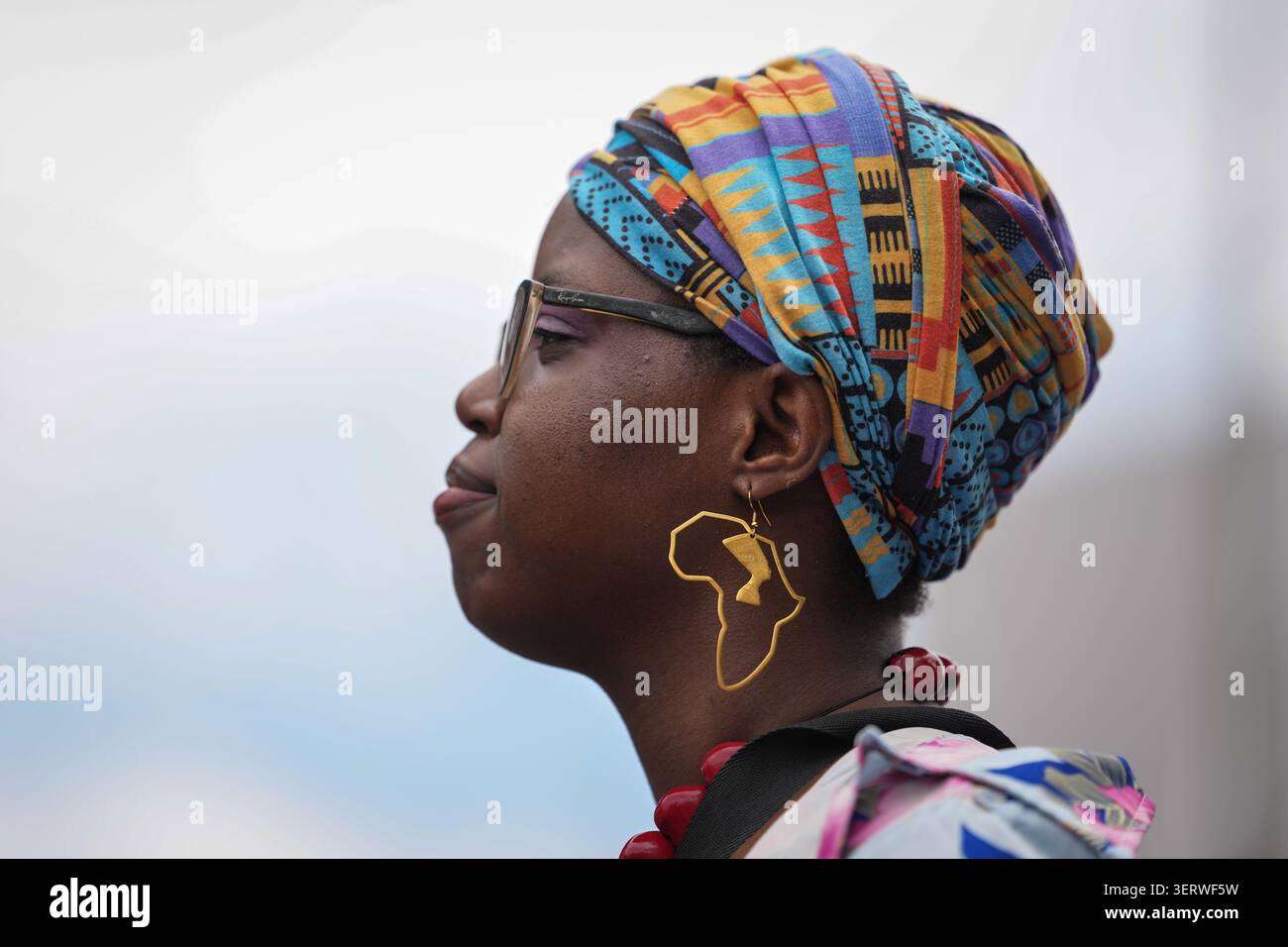 Marsha Cotton, wearing an African continent-shaped earring, watches a ...