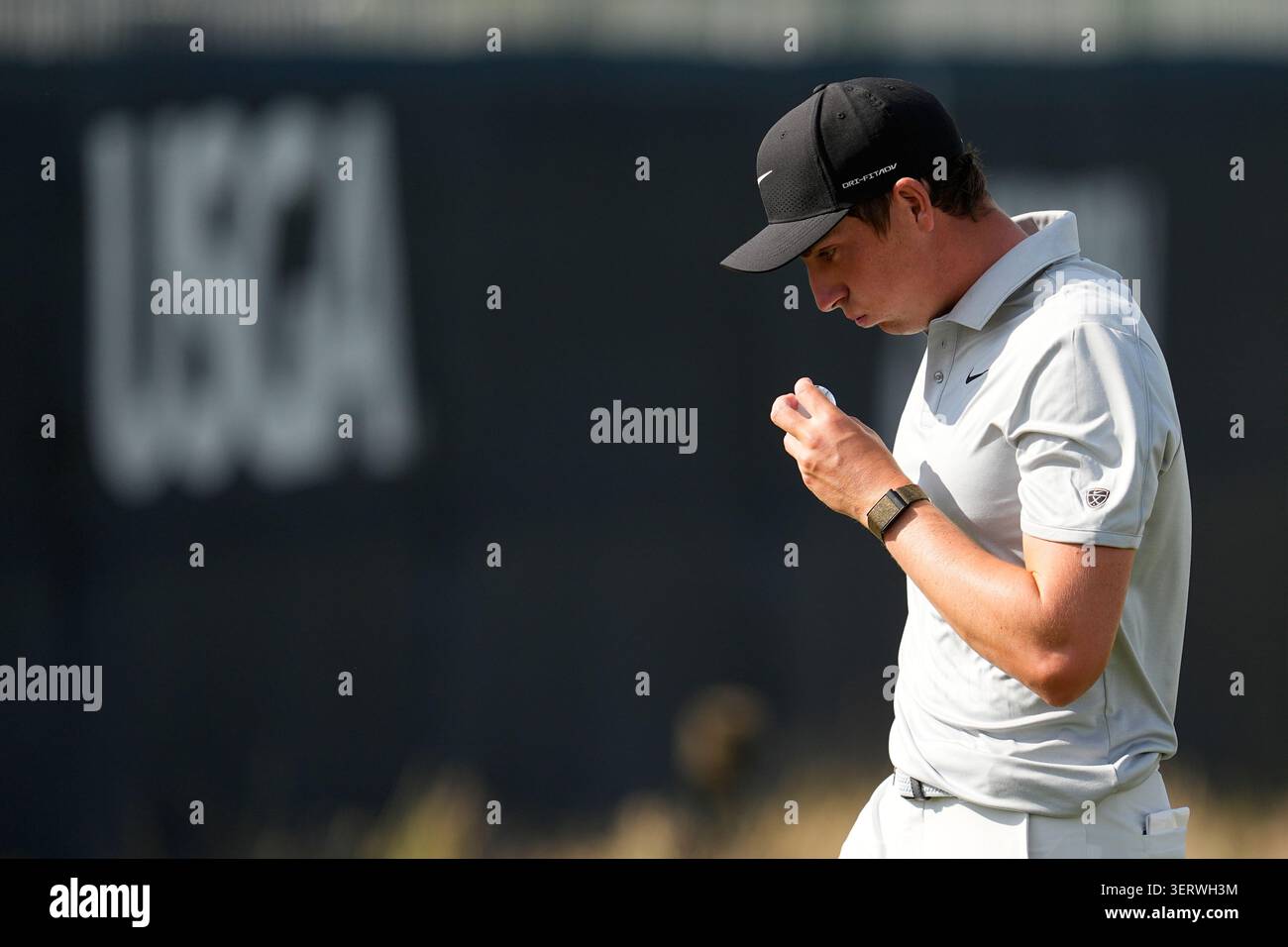 Ben James blows on his ball on the eighth hole during the second round ...