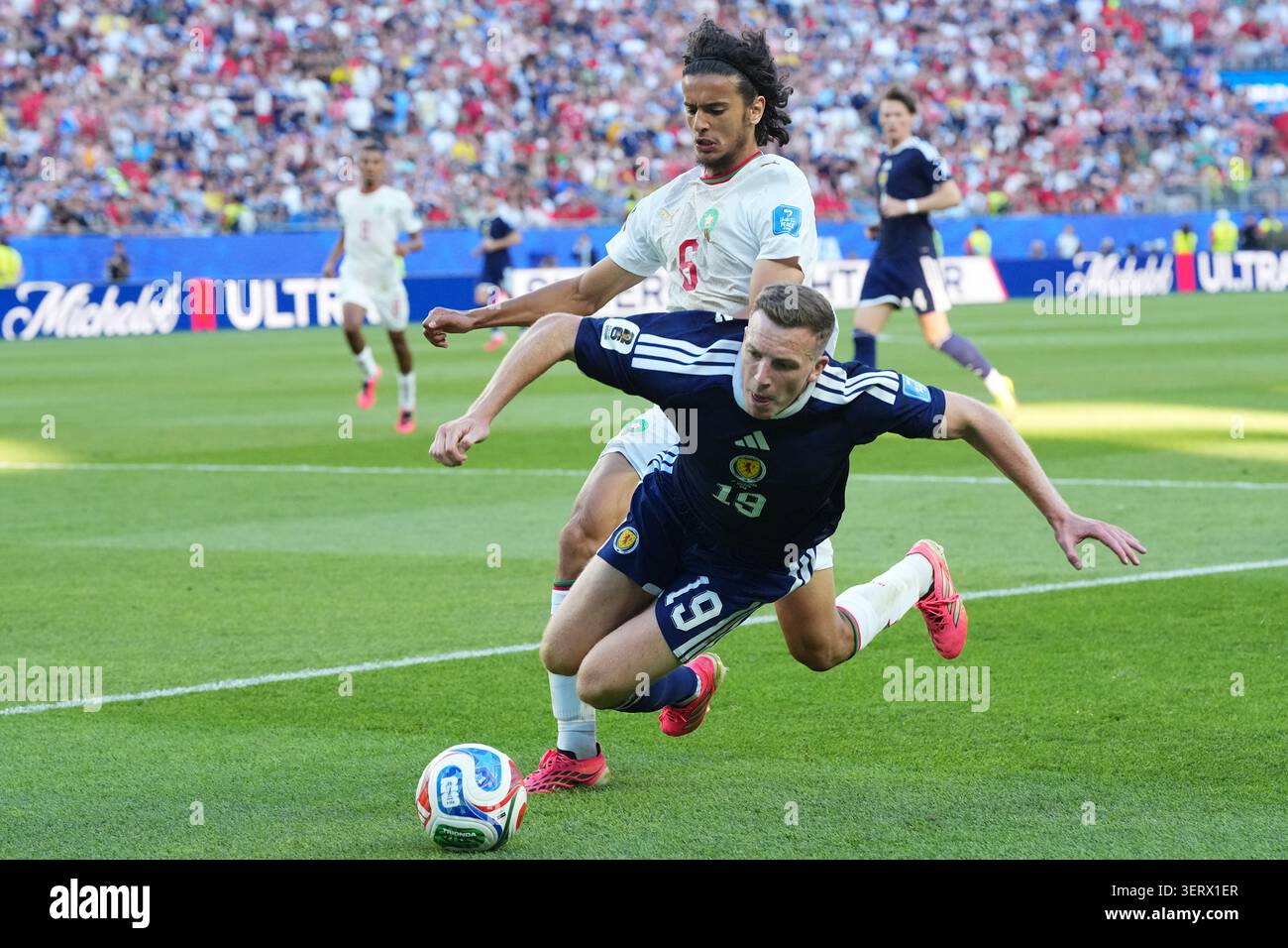 Scotland's Lewis Ferguson, front, falls on the pitch challenged by ...