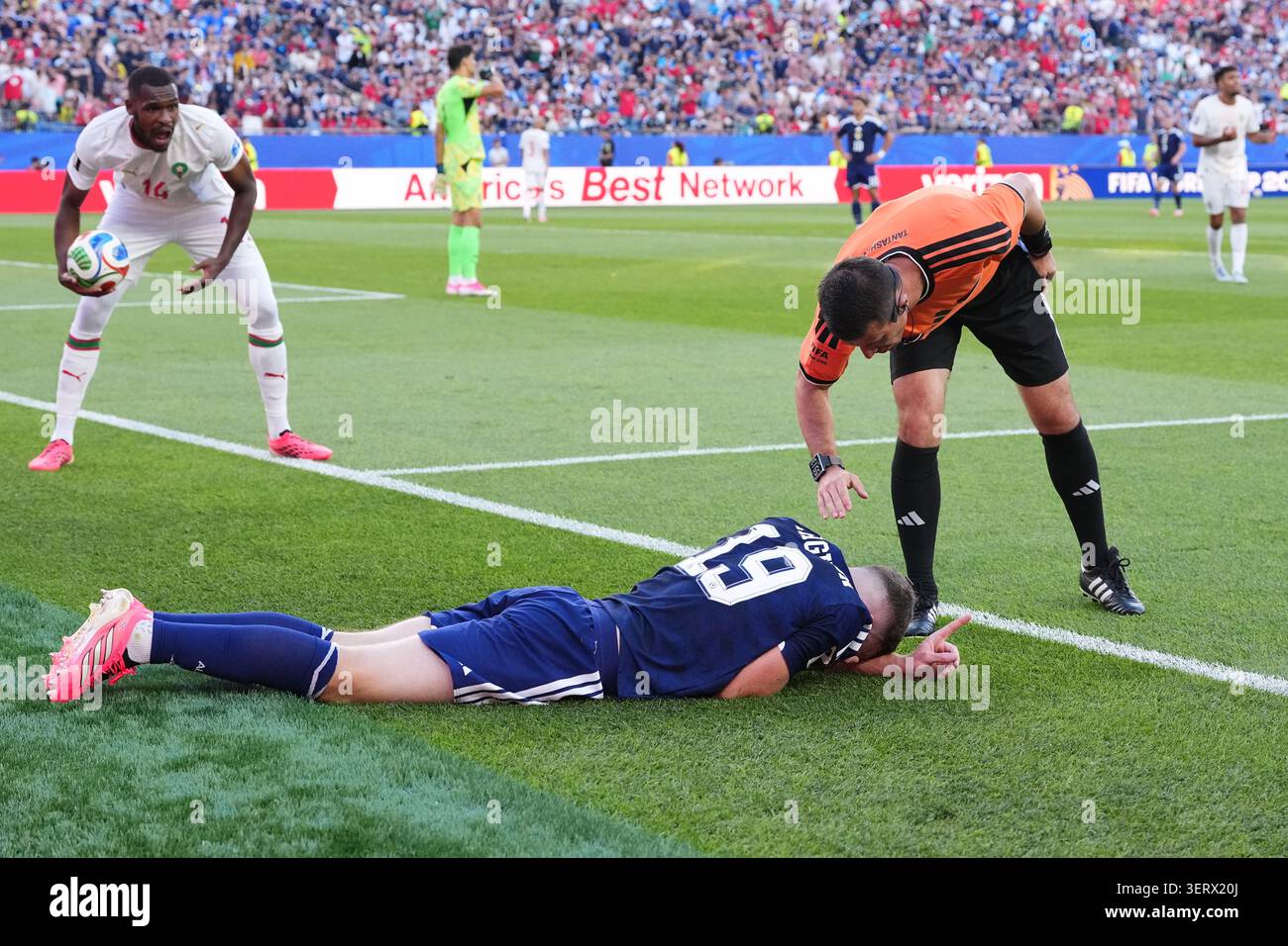 referee Ilgiz Tantashev, right, checks on Scotland's Lewis Ferguson ...