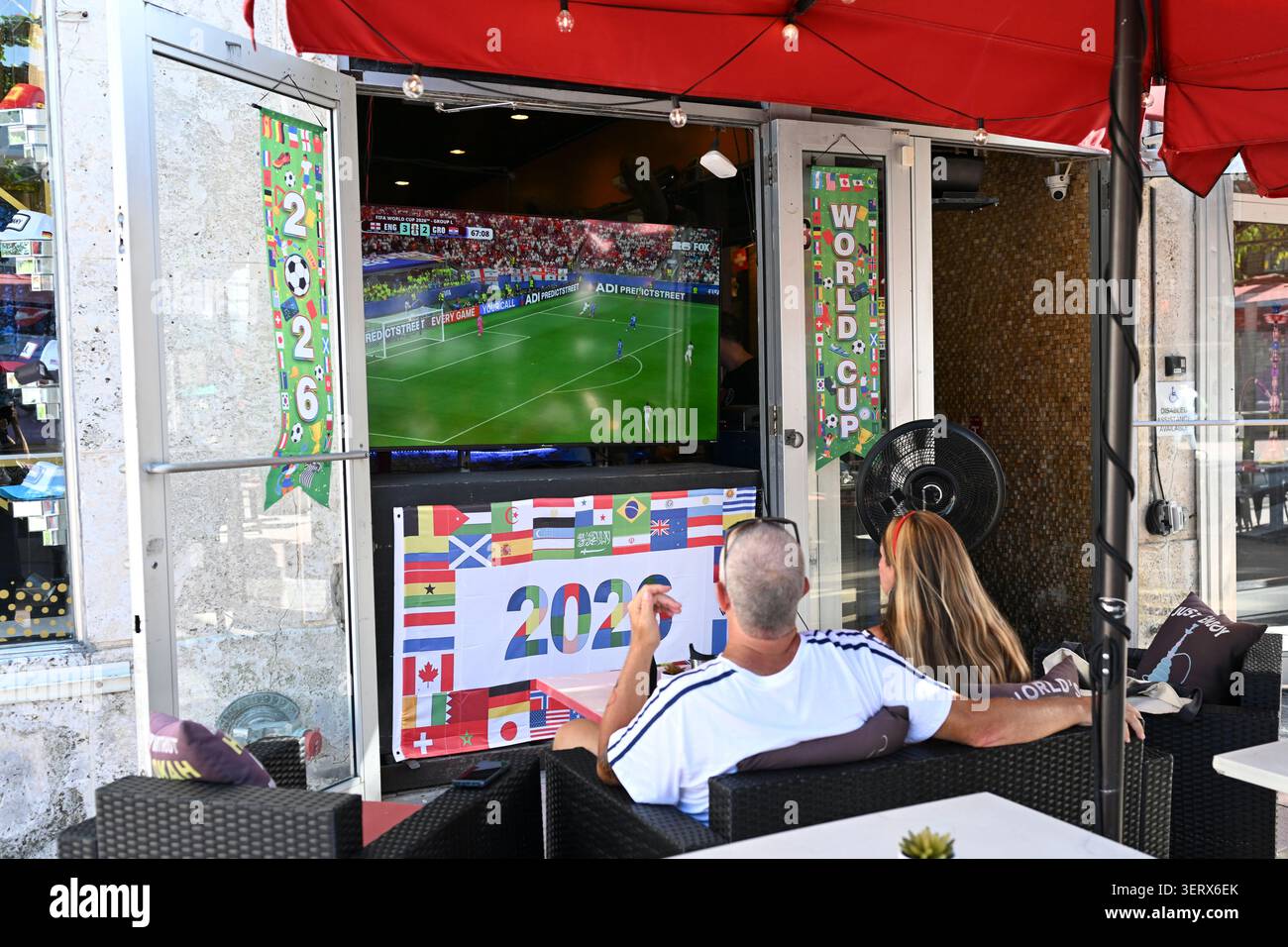 People dine outdoors while watching a FIFA World Cup match on a ...