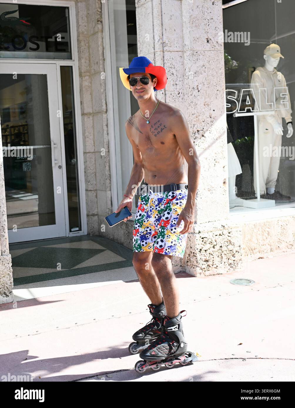 A man is seen wearing shorts with a soccer ball pattern, while ...