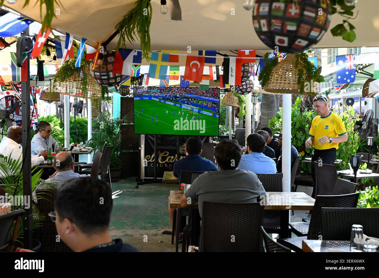 People dine outdoors while watching a FIFA World Cup match on a ...