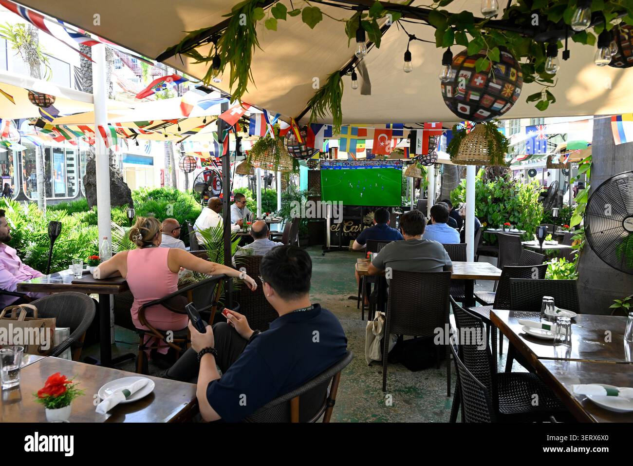 People dine outdoors while watching a FIFA World Cup match on a ...