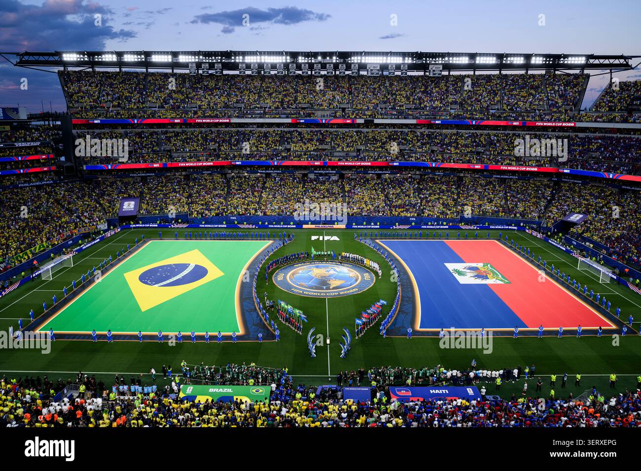 Players and officials line up as two large flags are displayed on the ...