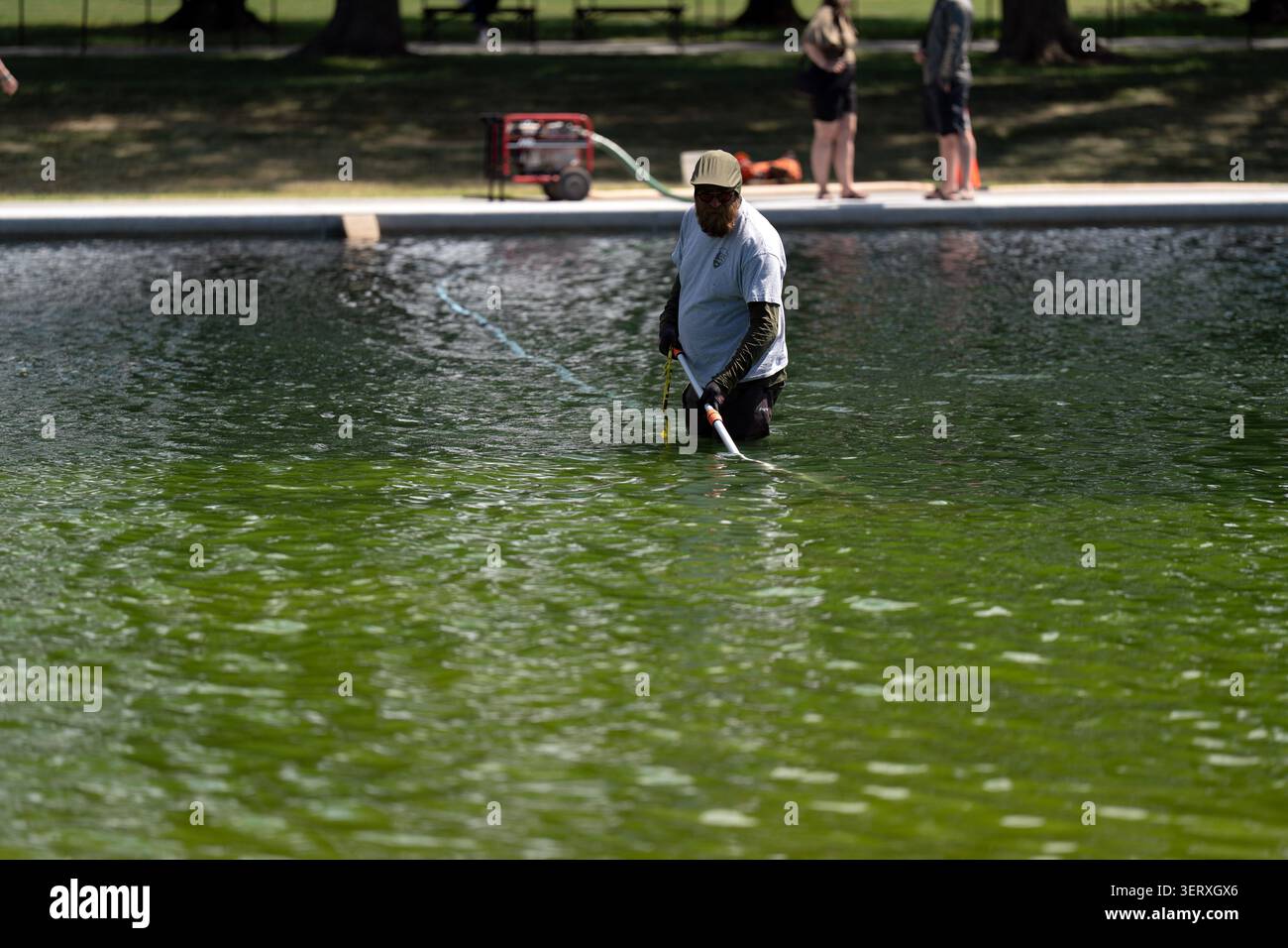 A member of the National Park Service uses a vacuum like device to ...