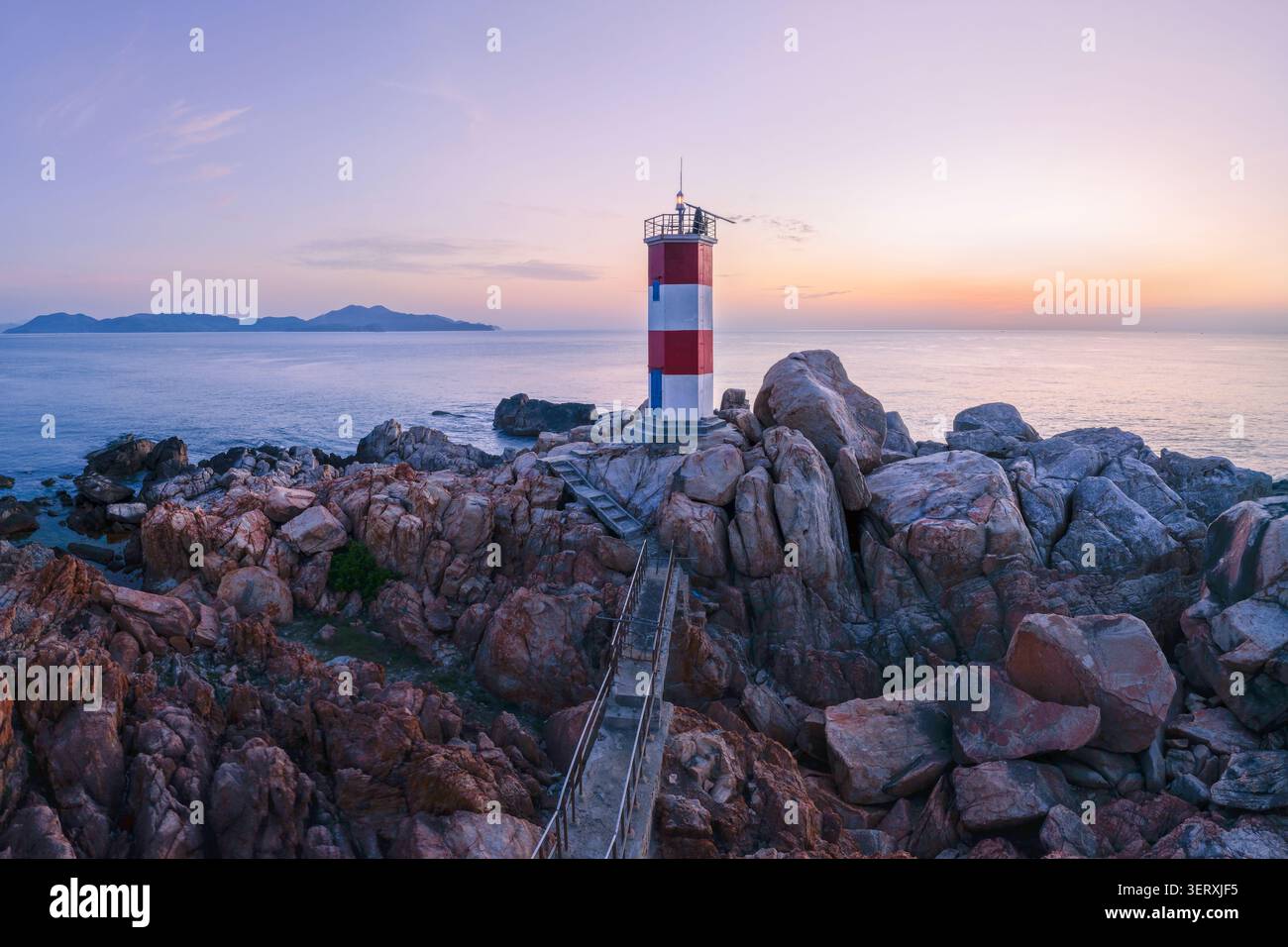 Ganh Den Lighthouse illuminated by the warm colors of sunrise on the ...