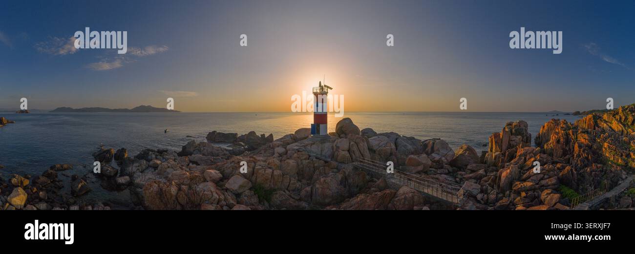 Ganh Den Lighthouse illuminated by the warm colors of sunrise on the ...
