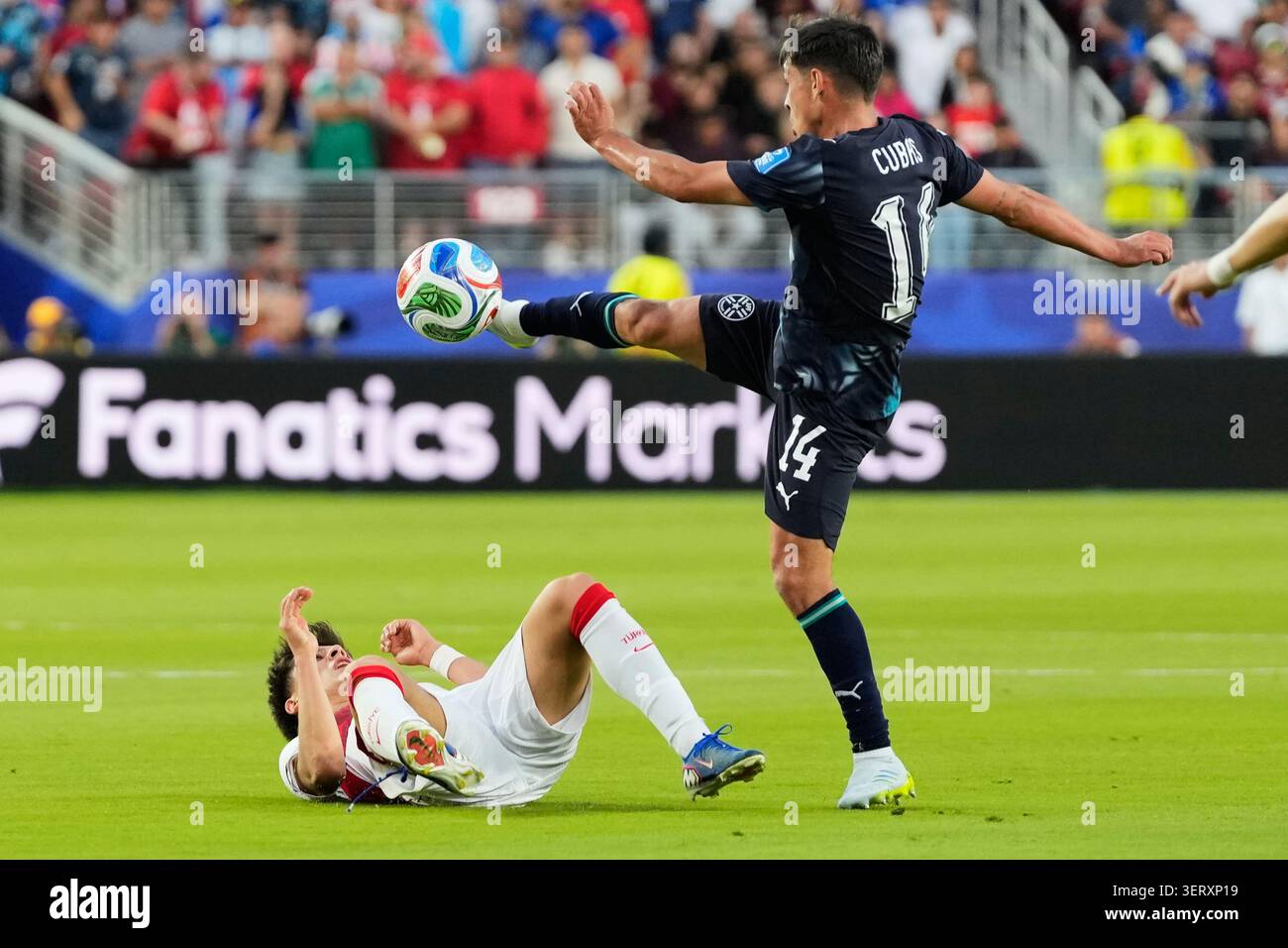 Paraguay's Andres Cubas (14) kicks the ball over Turkey's Arda Guler (8 ...