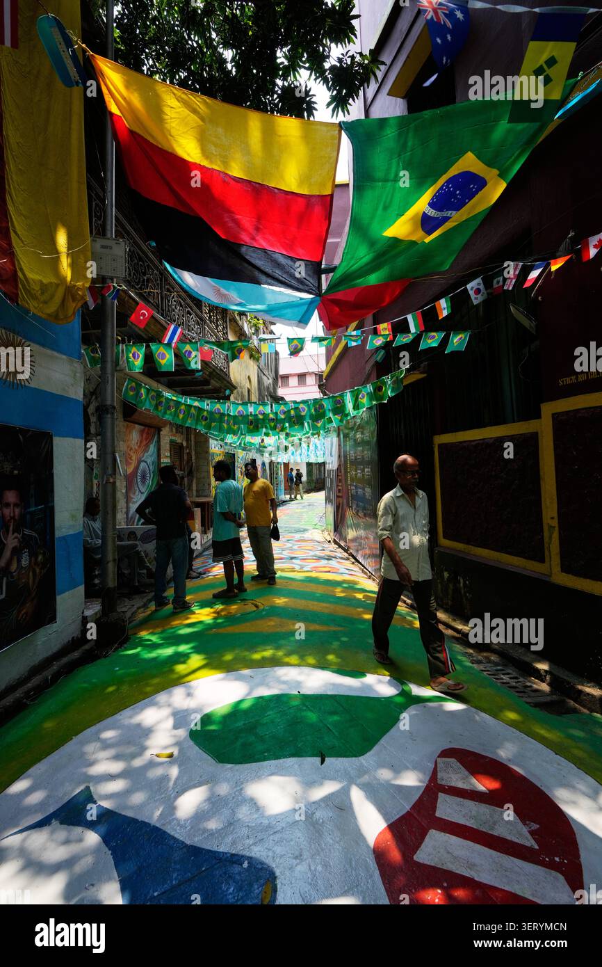 Commuters walks through a painted alley decorated with flags of ...
