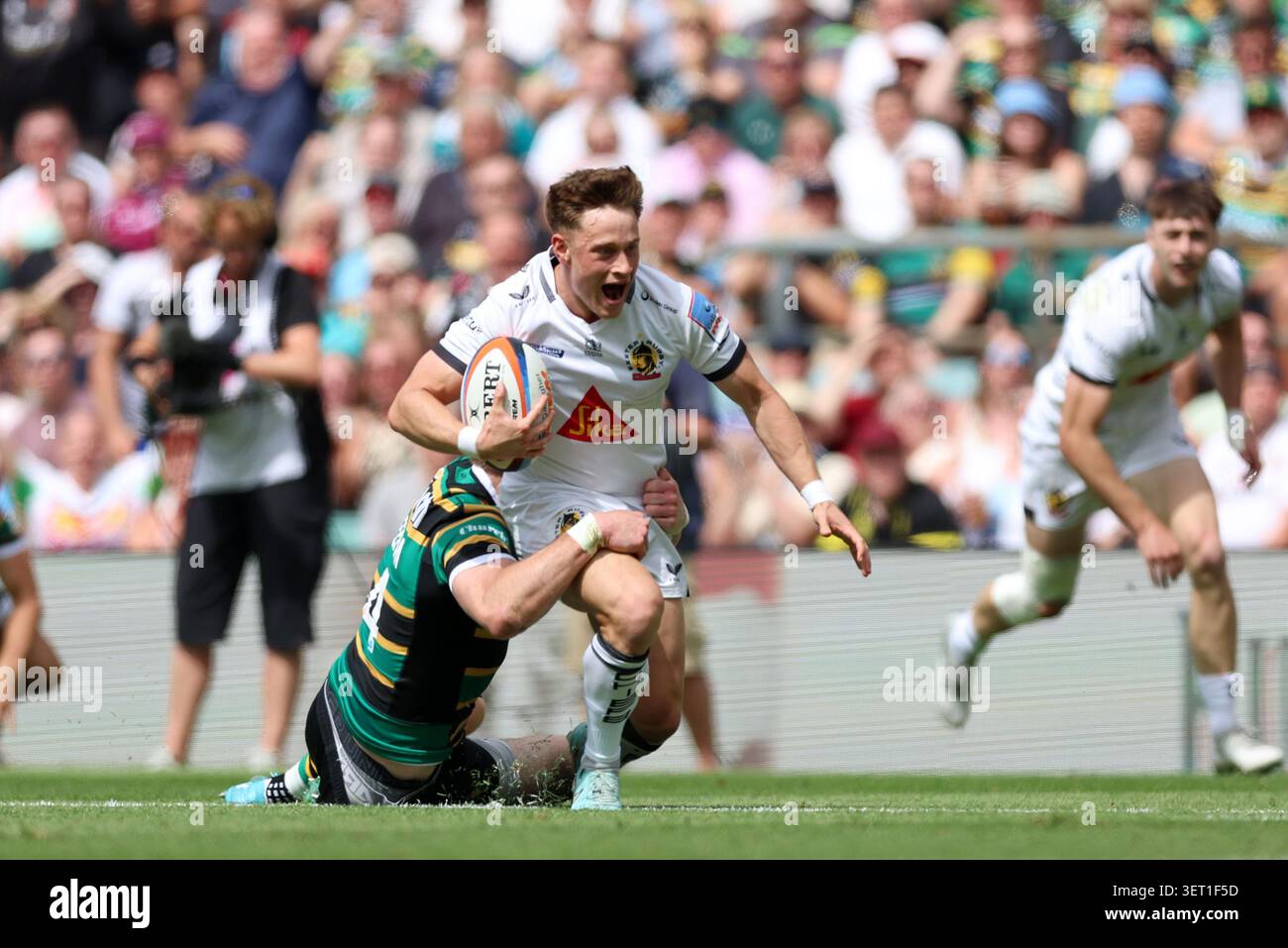 Exeter Chiefs' Stephen Varney (front) is tackled by Northampton Saints ...