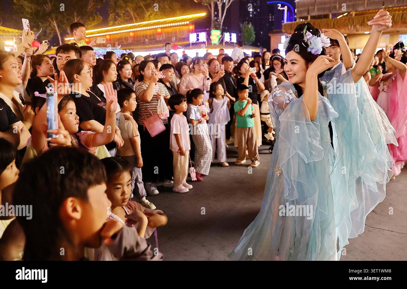 Tourists watch a dance performance at Qinhuang Alley in Haigang ...
