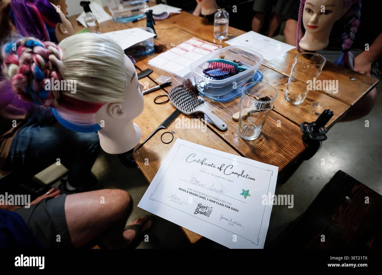 A completion certificate sits next to a mannequin head and empty pint ...