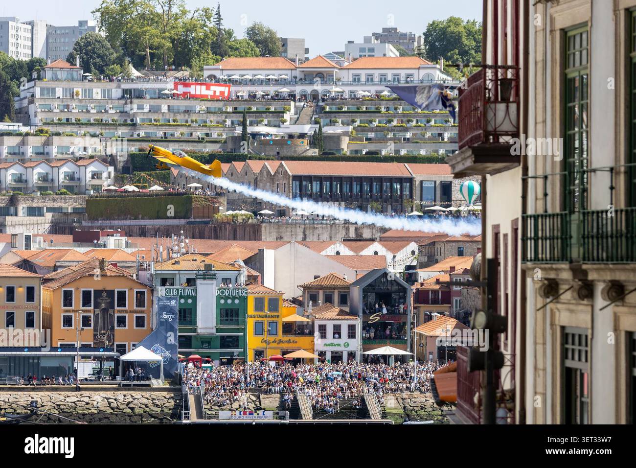 Porto, Portugal, 20 June 2026. A yellow aerobatic aircraft flies over ...