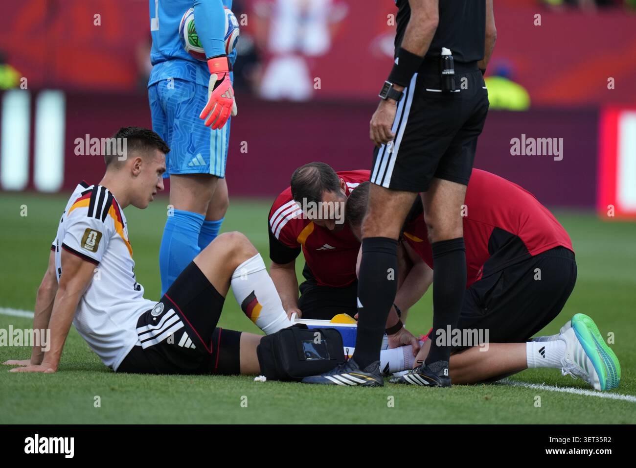 Germany's Nico Schlotterbeck receives treatment following an injury ...