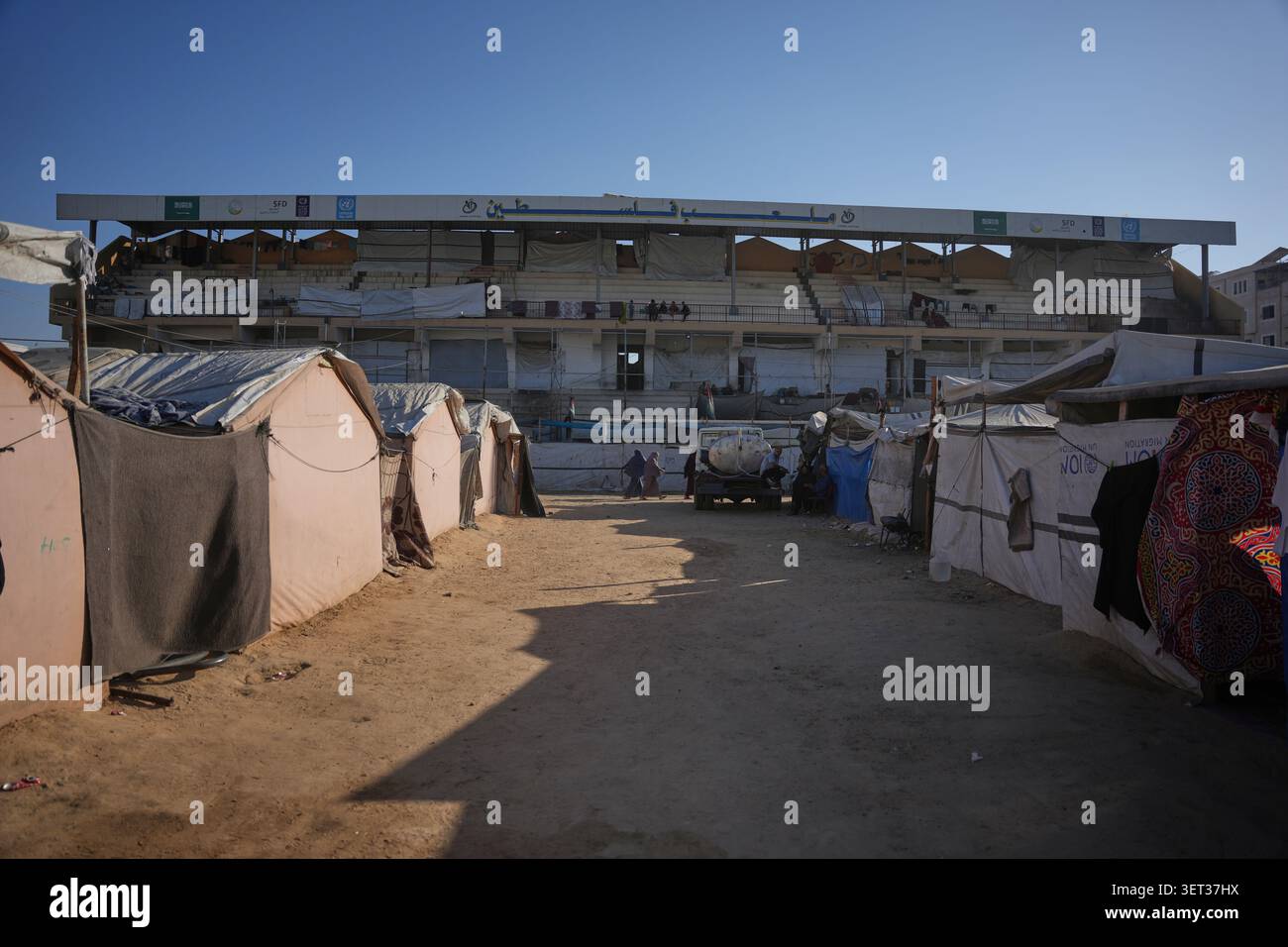 Tents of displaced Palestinians occupy the field of the soccer stadium ...