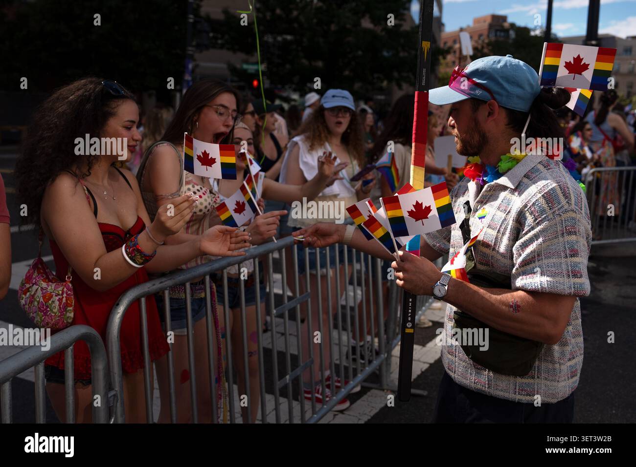 A participant hands out Canadian flags as he walks with the Embassy of ...