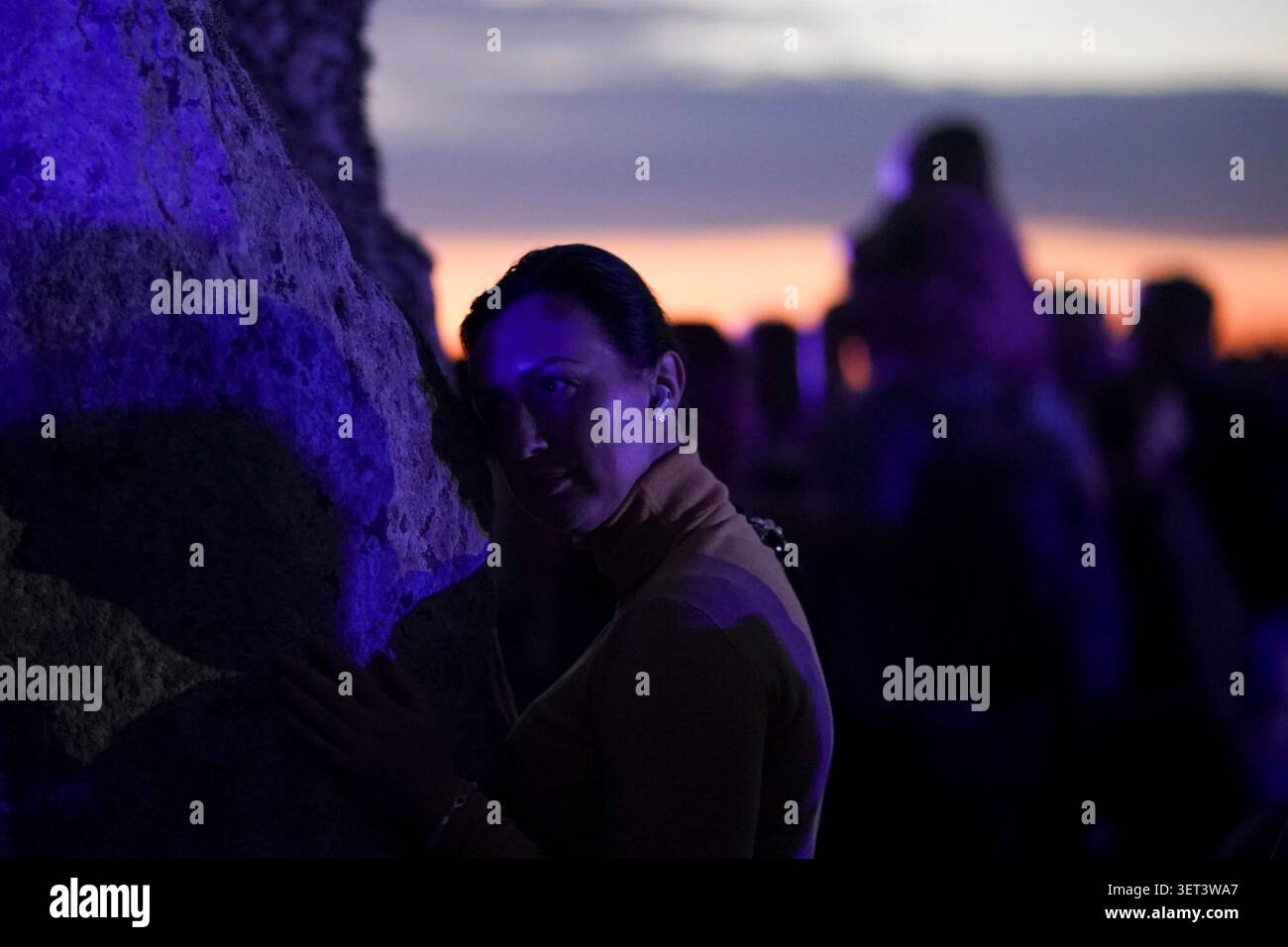 A reveller touches a stone at the ancient stone circle Stonehenge to ...