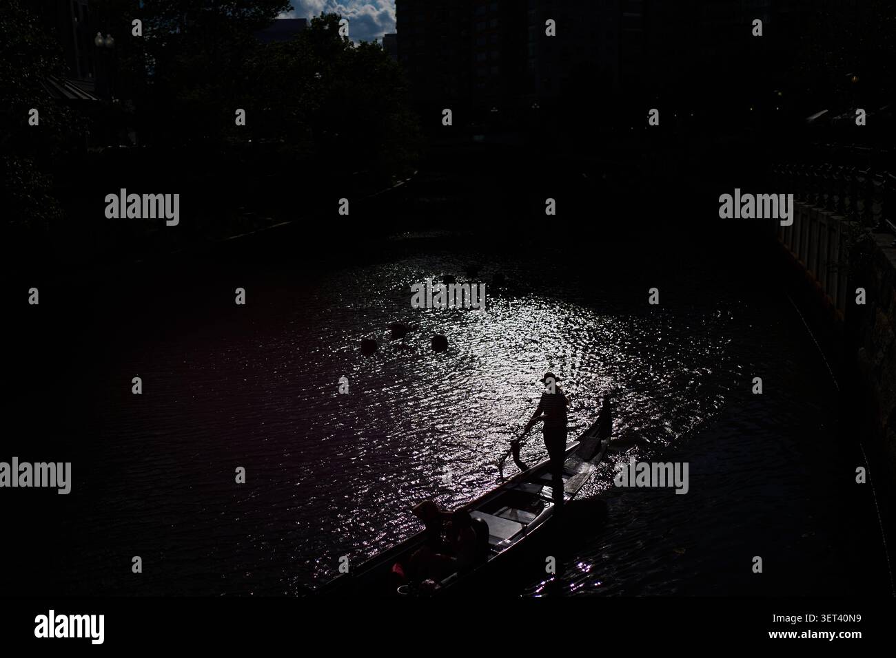 A gondolier navigates the Woonasquatucket River while taking tourists ...
