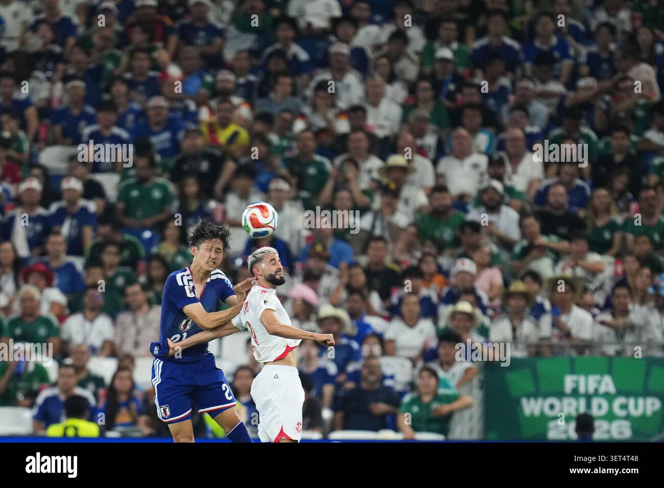 Japan's Hiroki Ito, left, and Tunisia's Elias Saad go for a header ...