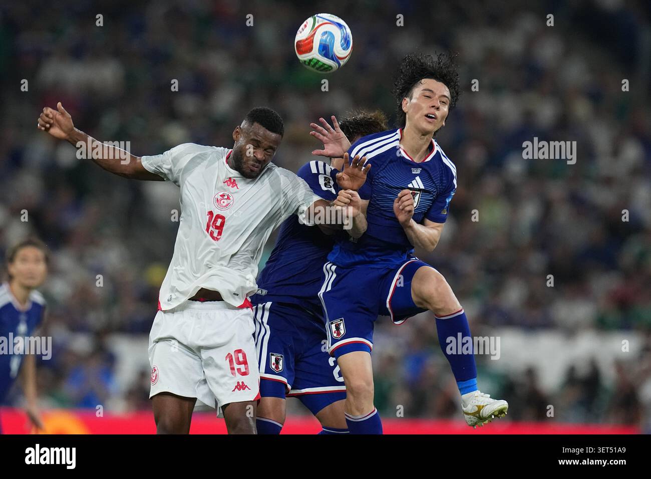 Tunisia's Firas Chaouat, left, and Japan's Ao Tanaka go for a header ...