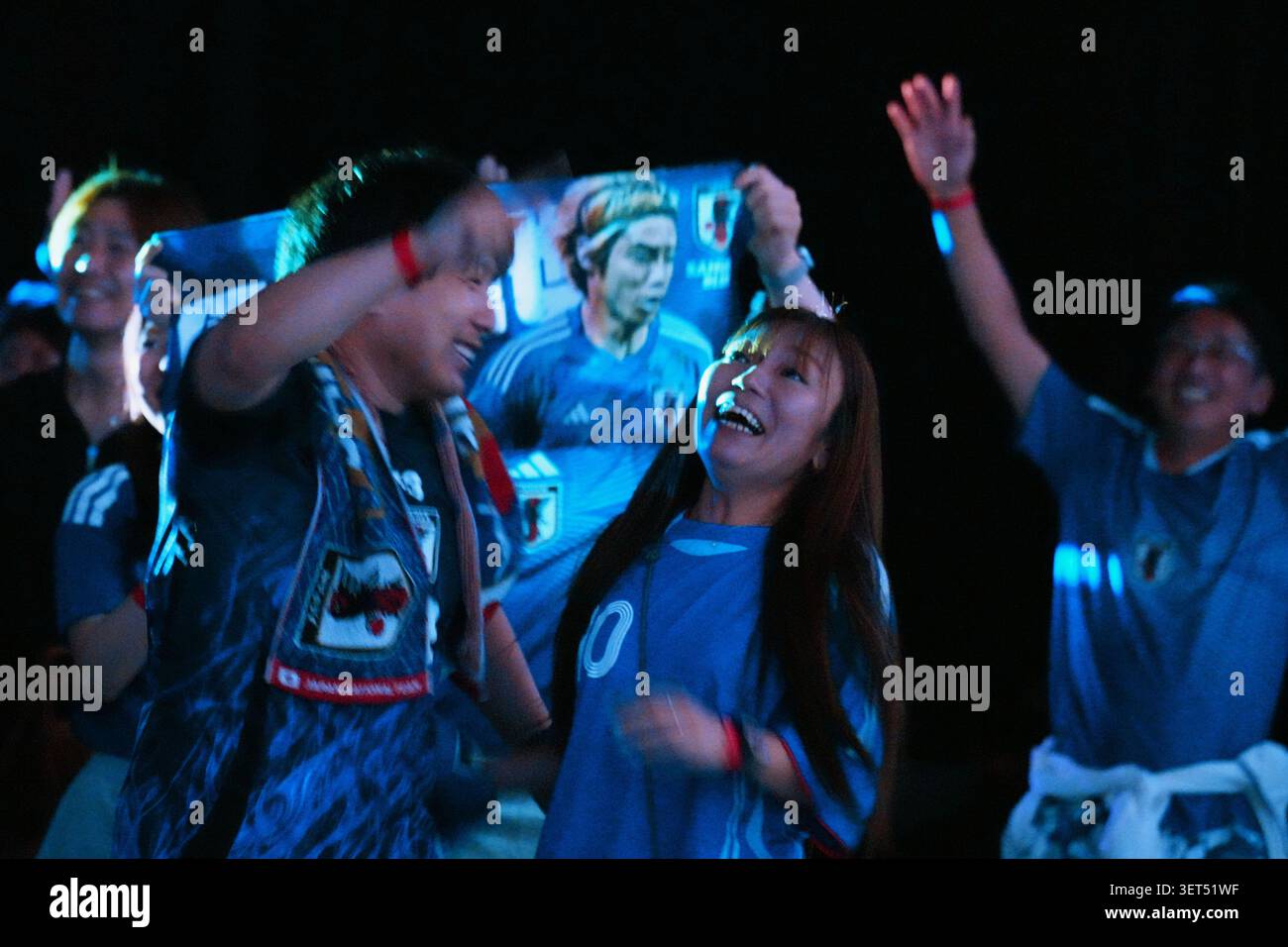 Fans react to Japan's third goal as they watch the second half of their ...