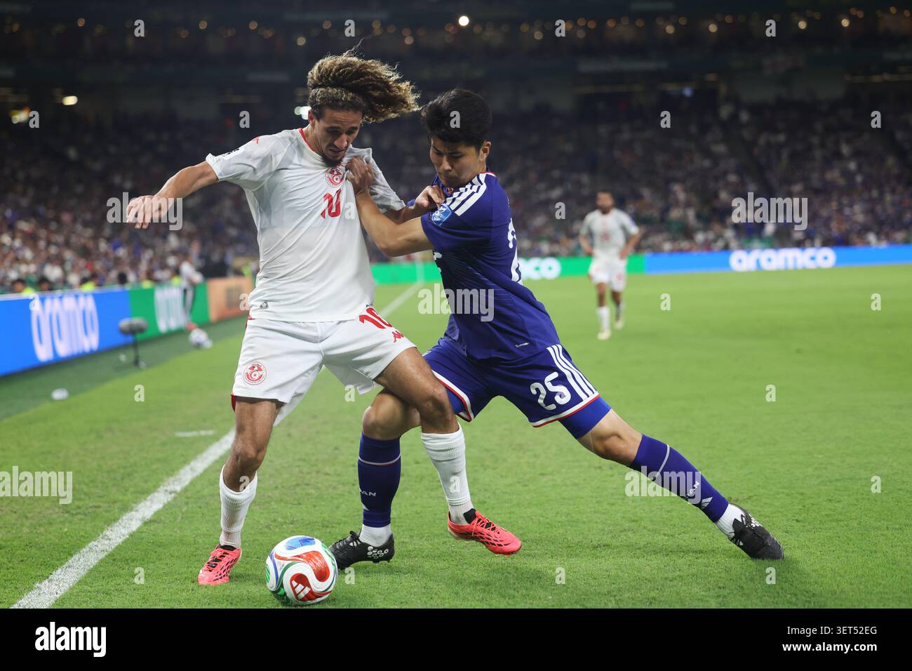Tunisia's Hannibal Mejbri (10) and Japan's Junnosuke Suzuki (25) battle ...