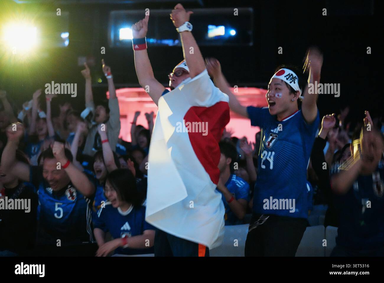 Fans react to Japan's third goal as they watch the second half of their ...