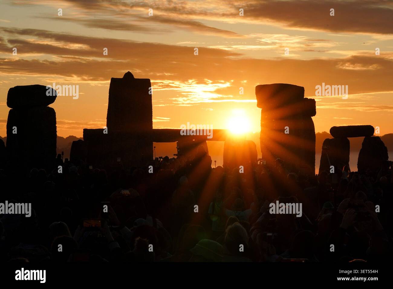 Revelers gather at the ancient stone circle Stonehenge at sunrise to ...