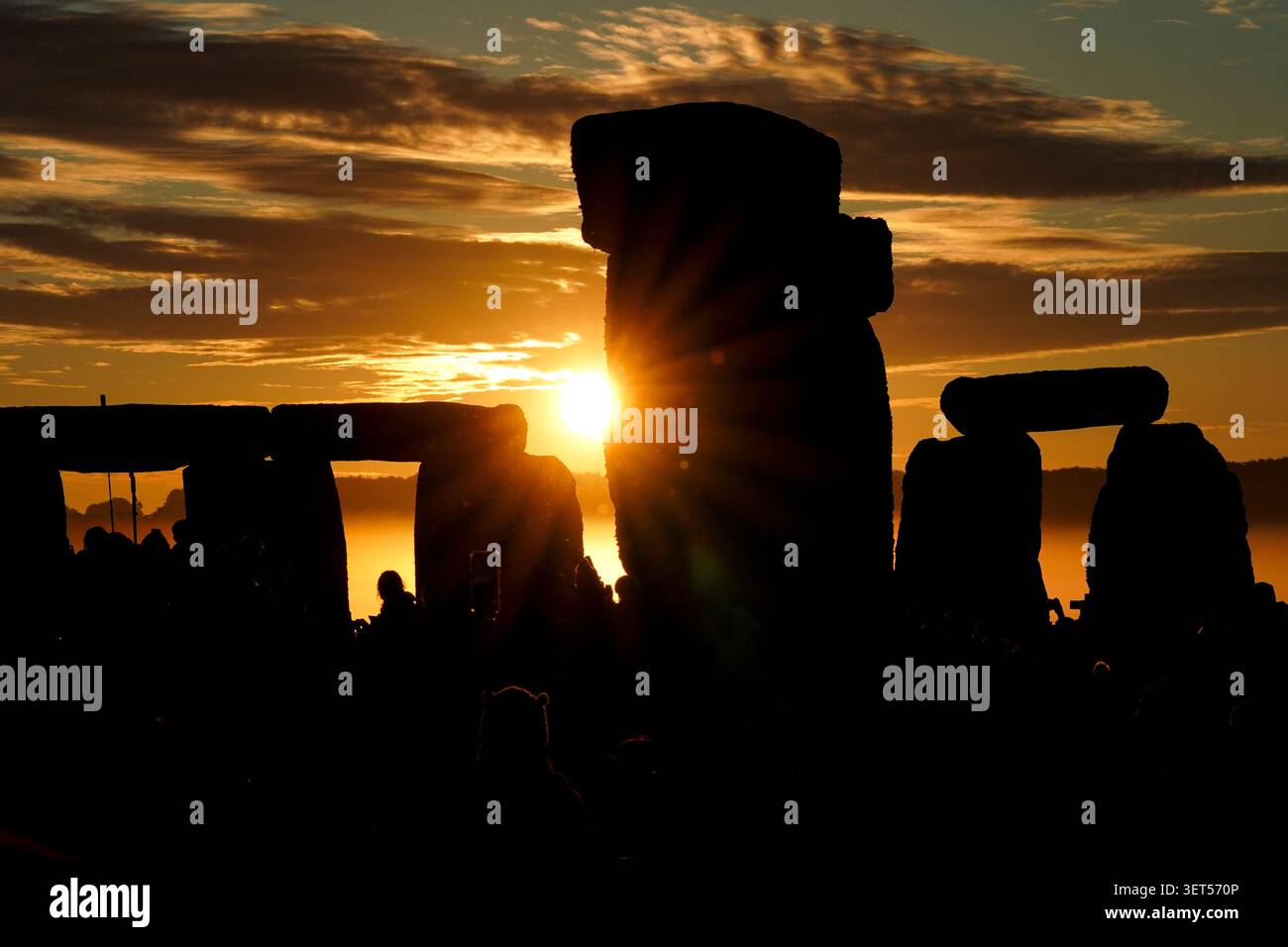 Revelers gather at the ancient stone circle Stonehenge at sunrise to ...