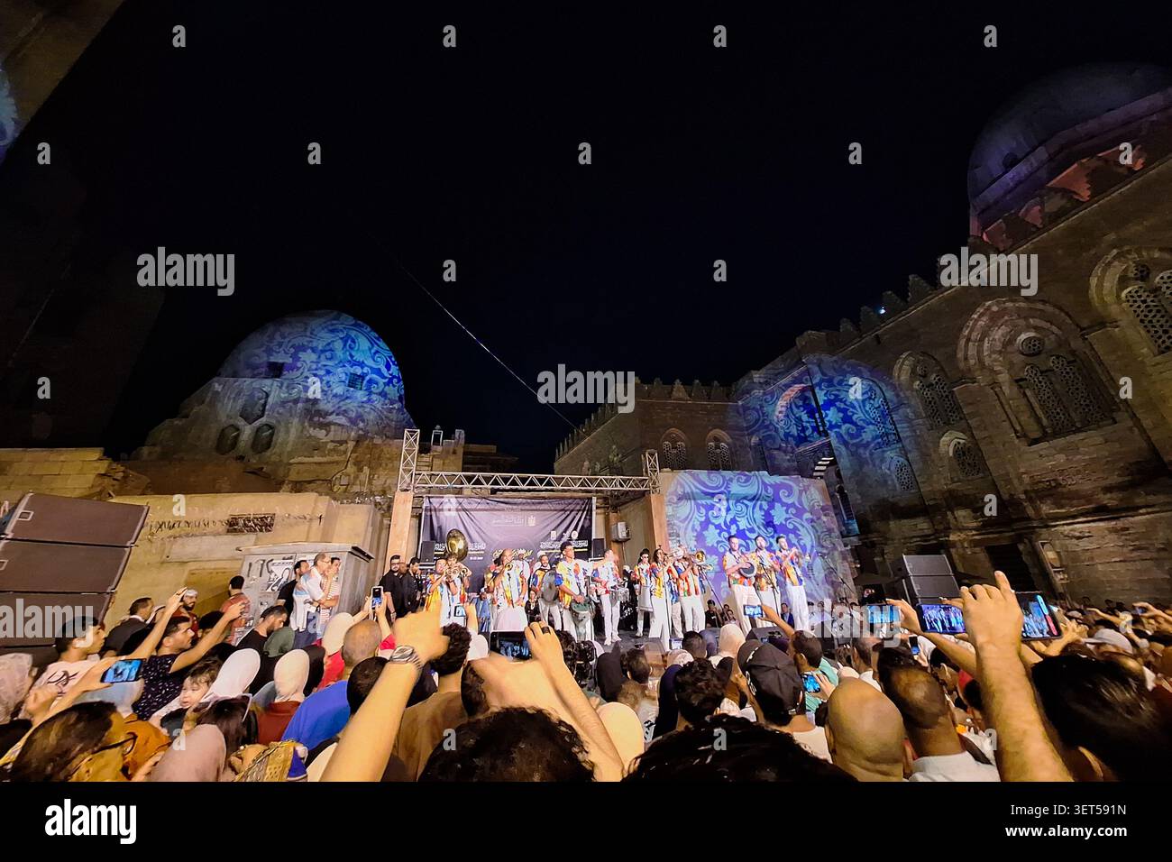 People watch the Egyptian drum band in Al-Muizz Street, a tourist area ...