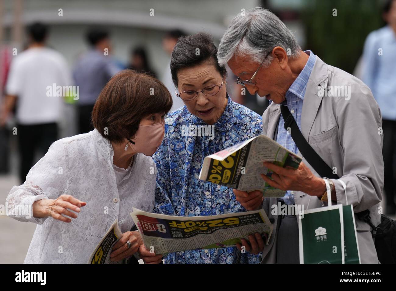 People read the extra copy of the Hochi Shimbun newspaper handed out on ...