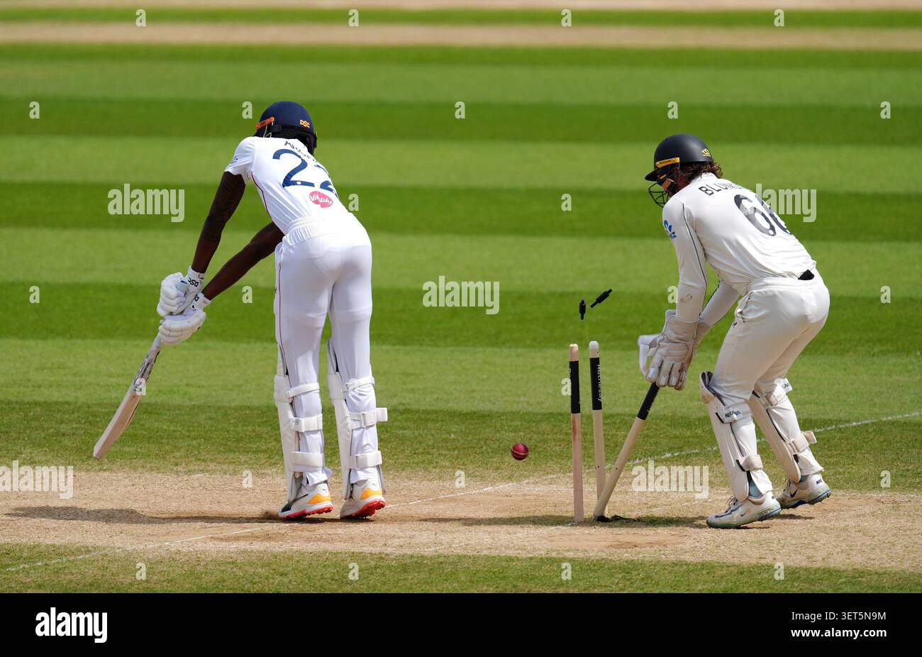 England's Jofra Archer (left) is bowled out by New Zealand's Matt Henry ...