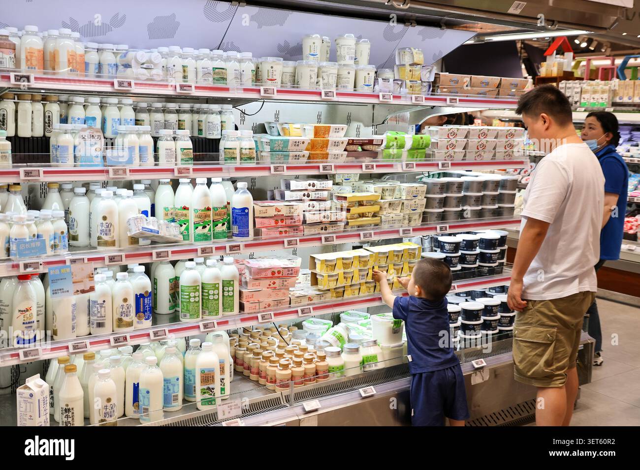 Shoppers select fresh milk and yogurt at a Hema supermarket in Shanghai ...