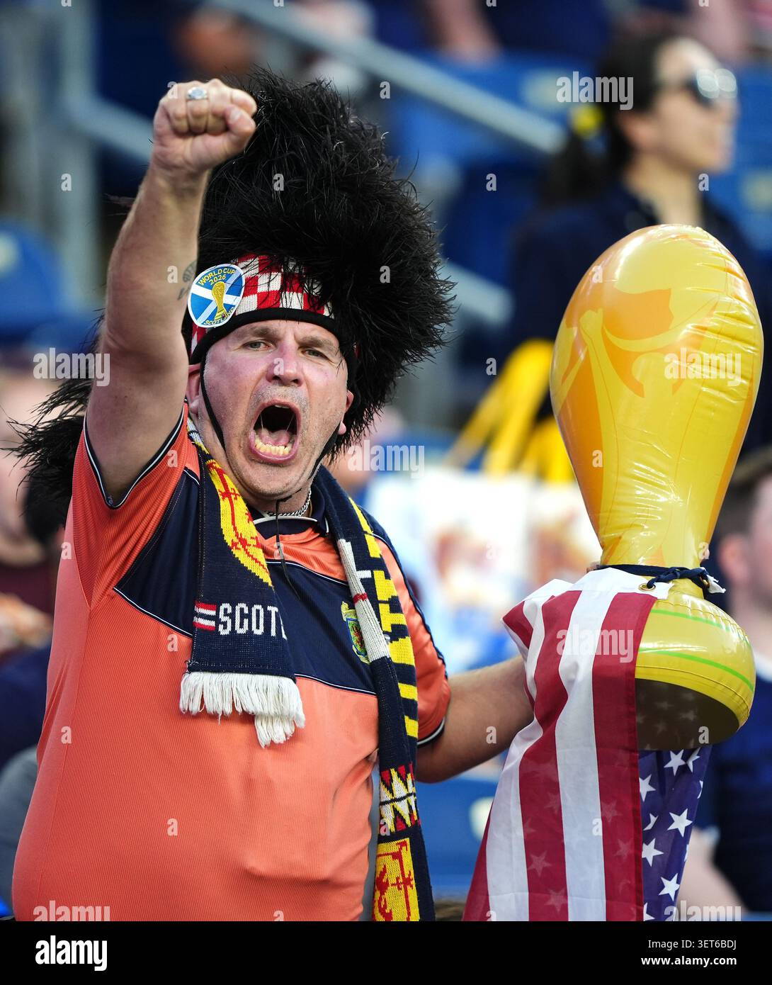 A Scotland fan wearing a bearskin hat and holding an inflatable trophy ...