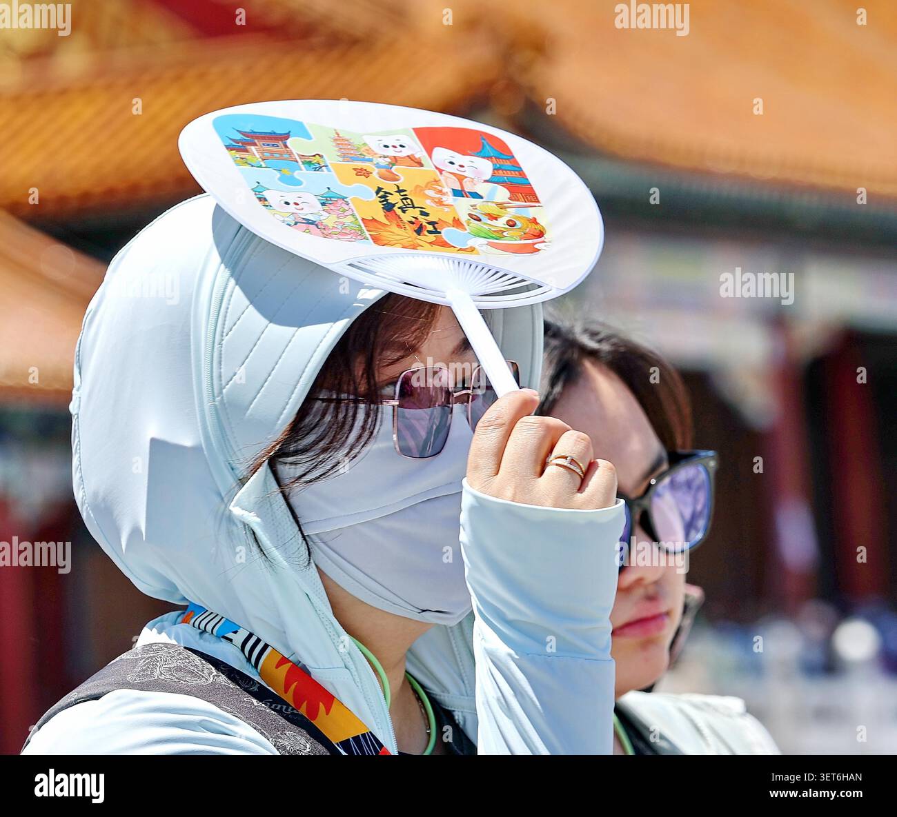Tourists use various sun protection methods at the Forbidden City in ...