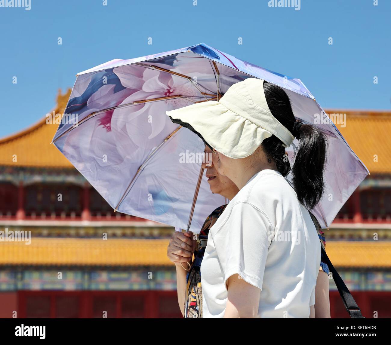 Tourists use various sun protection methods at the Forbidden City in ...