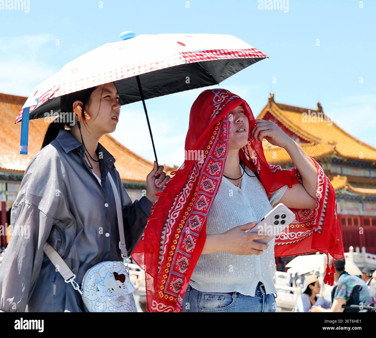 Tourists use various sun protection methods at the Forbidden City in ...