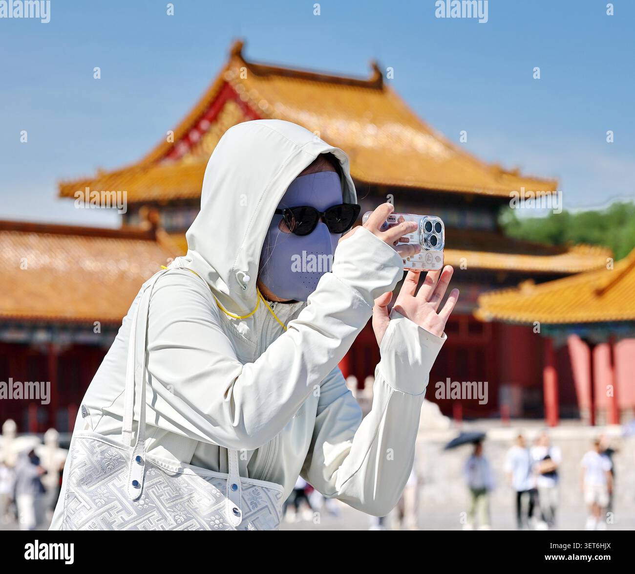 Tourists use various sun protection methods at the Forbidden City in ...